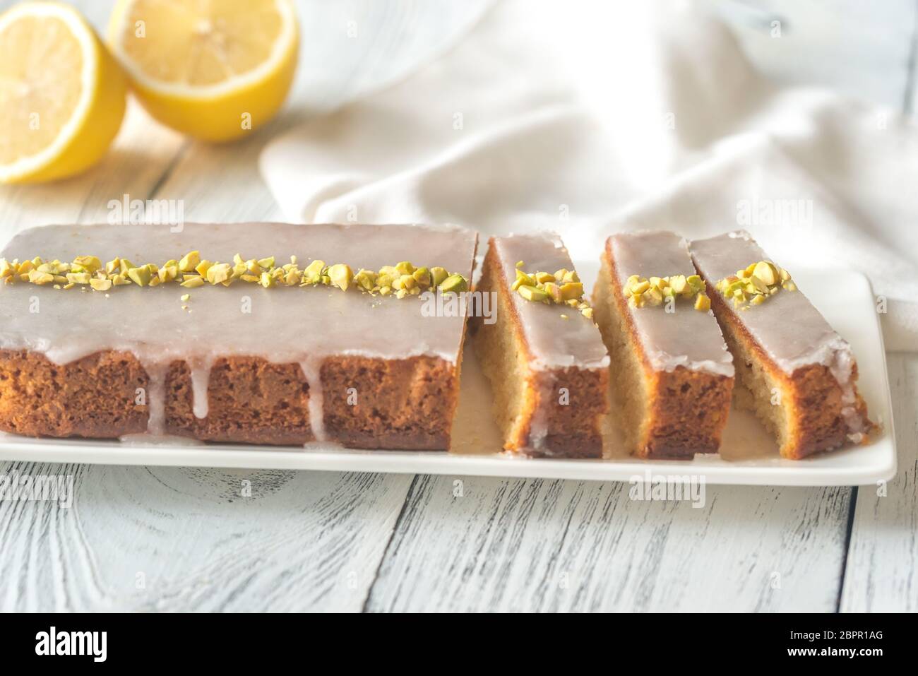 Lemon cake with icing decorated with pistachios: top view Stock Photo ...
