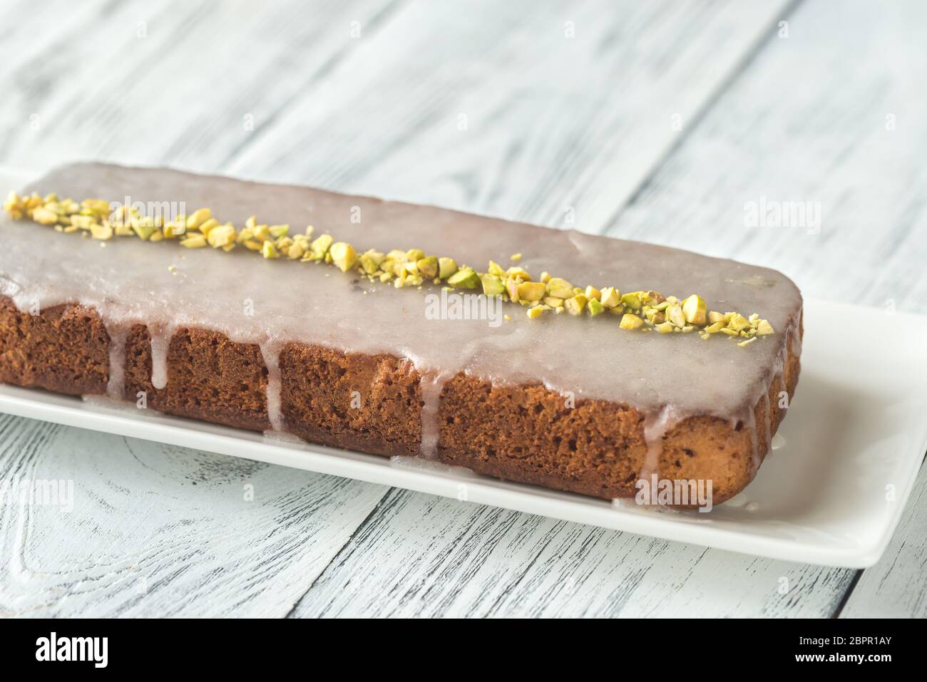 Lemon cake with icing decorated with pistachios: top view Stock Photo ...
