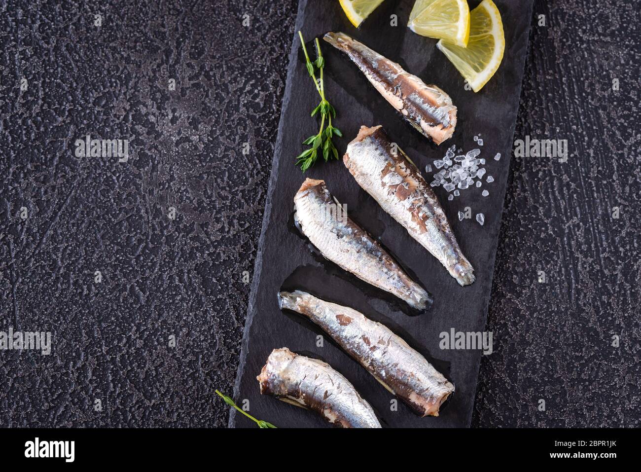 Sardines on the black stone board: top view Stock Photo - Alamy