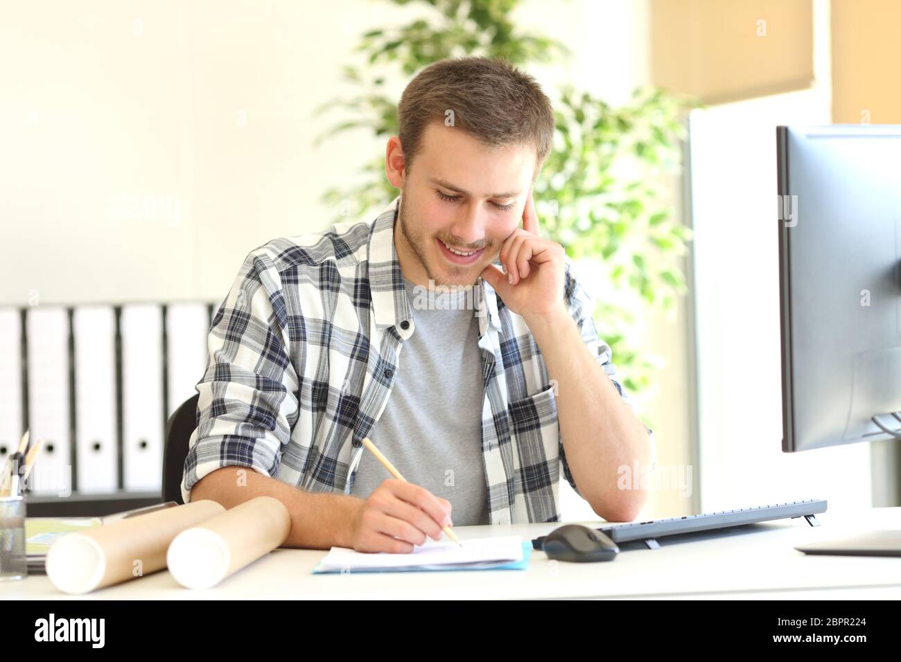 Designer or architect working writing notes at office Stock Photo - Alamy