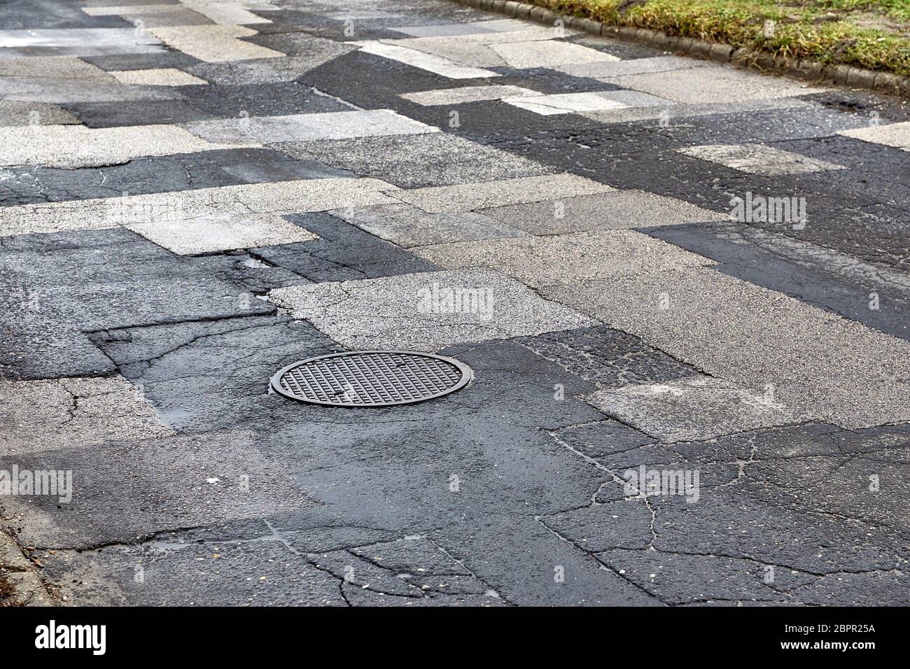 Extremely bad quality road with many patches, potholes Stock Photo - Alamy