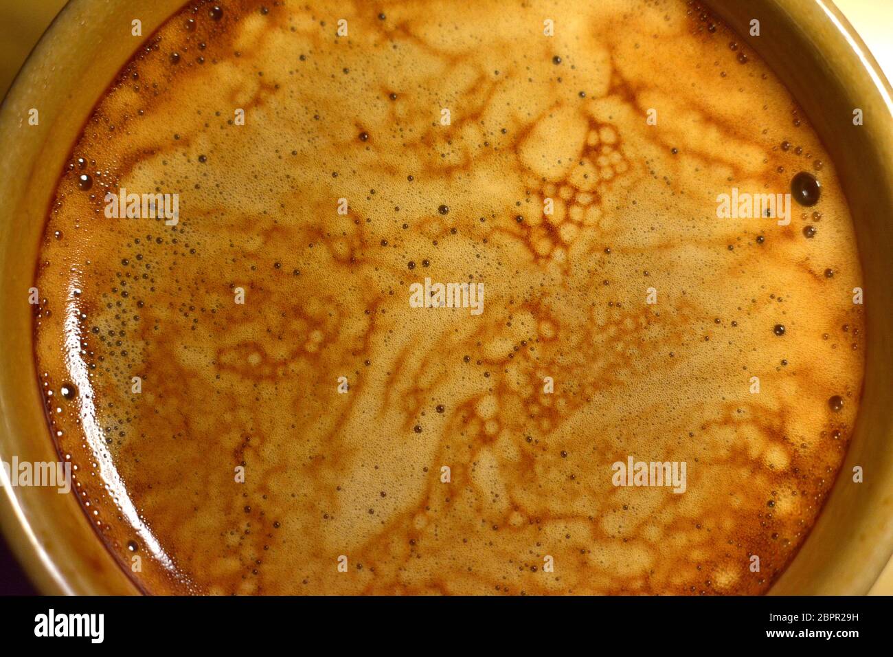 A cup of instant coffee with a little bit of milk, in close-up view ...