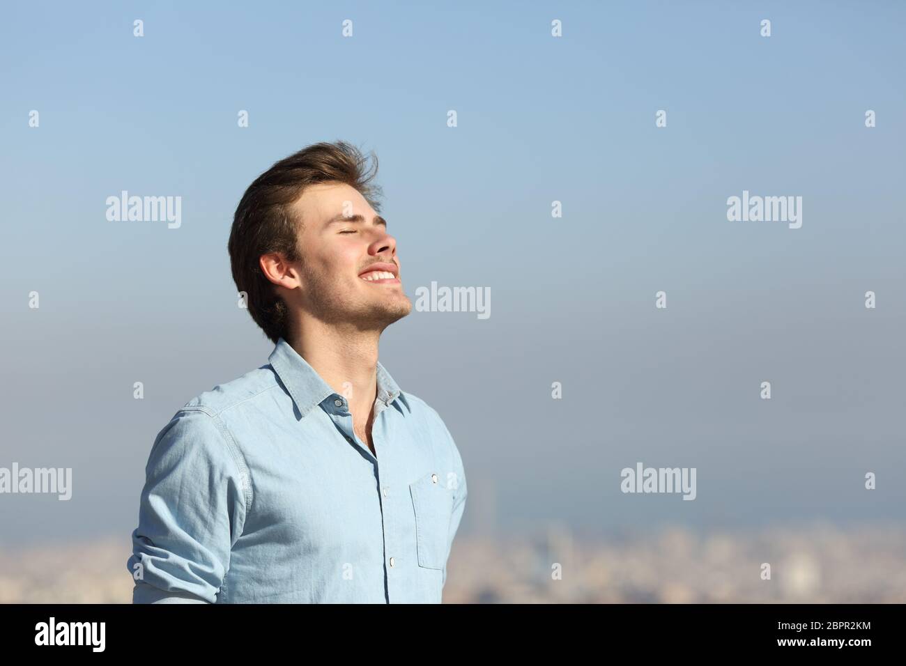 Happy man breathing deeply fresh air in the city outskirts Stock Photo ...