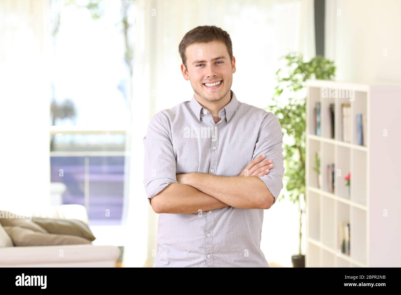 Happy homeowner portrait posing standing at home with furniture and ...