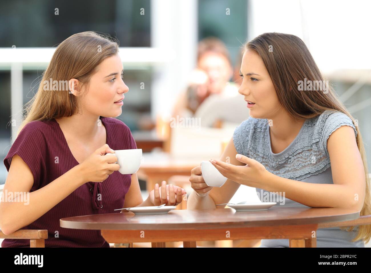 Two serious friends talking sitting in a restaurant Stock Photo - Alamy
