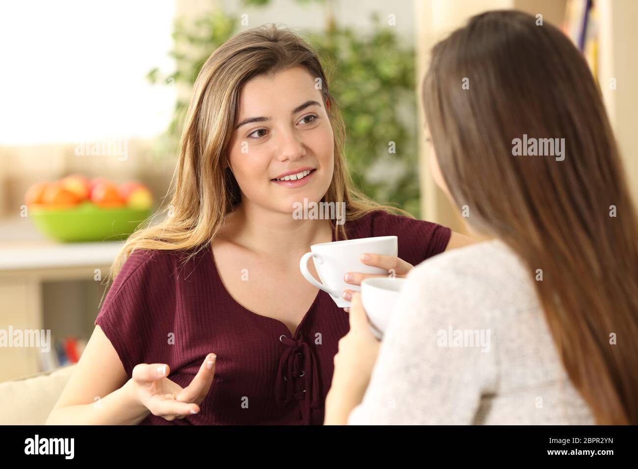 Two girls talk on sofa hi-res stock photography and images - Alamy