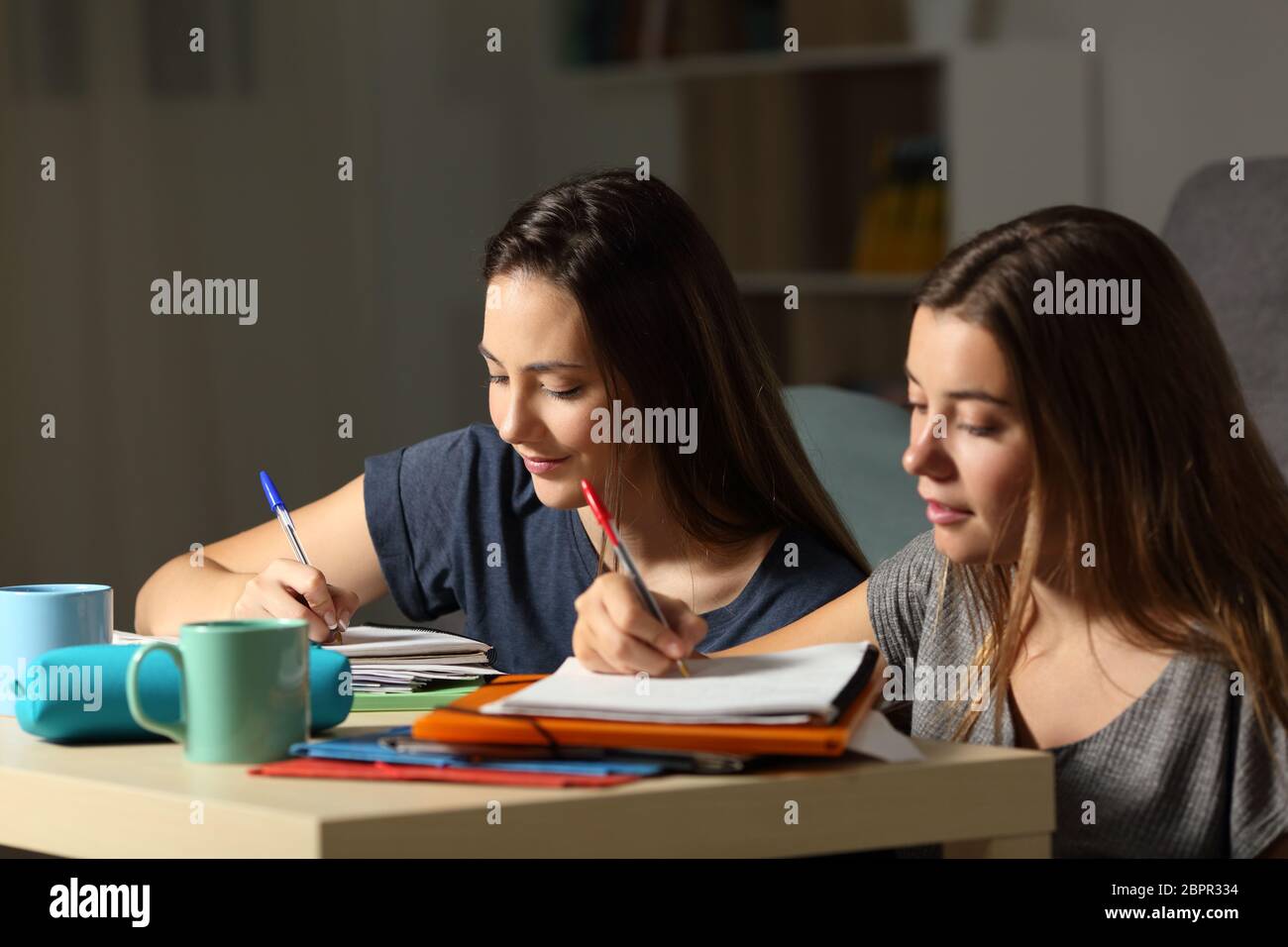 Two students doing homework together in the night at home Stock Photo ...