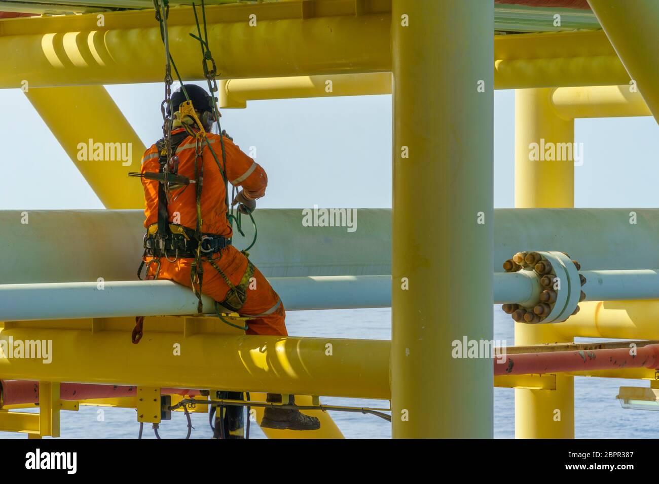 Working at height. An abseiler with dirty coverall wearing Personal ...