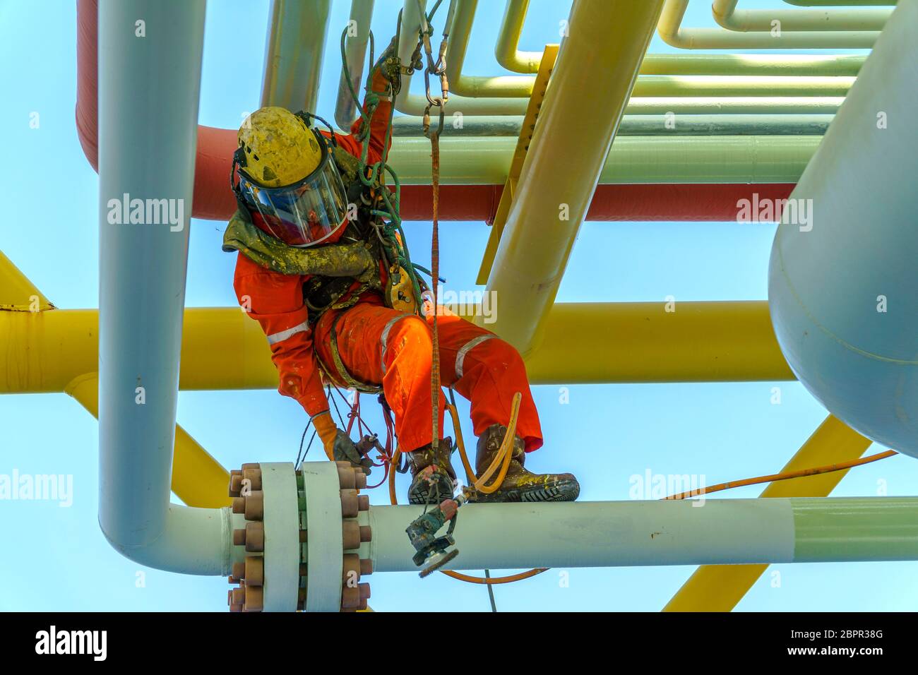 Working at height. An abseiler with dirty coverall wearing Personal ...
