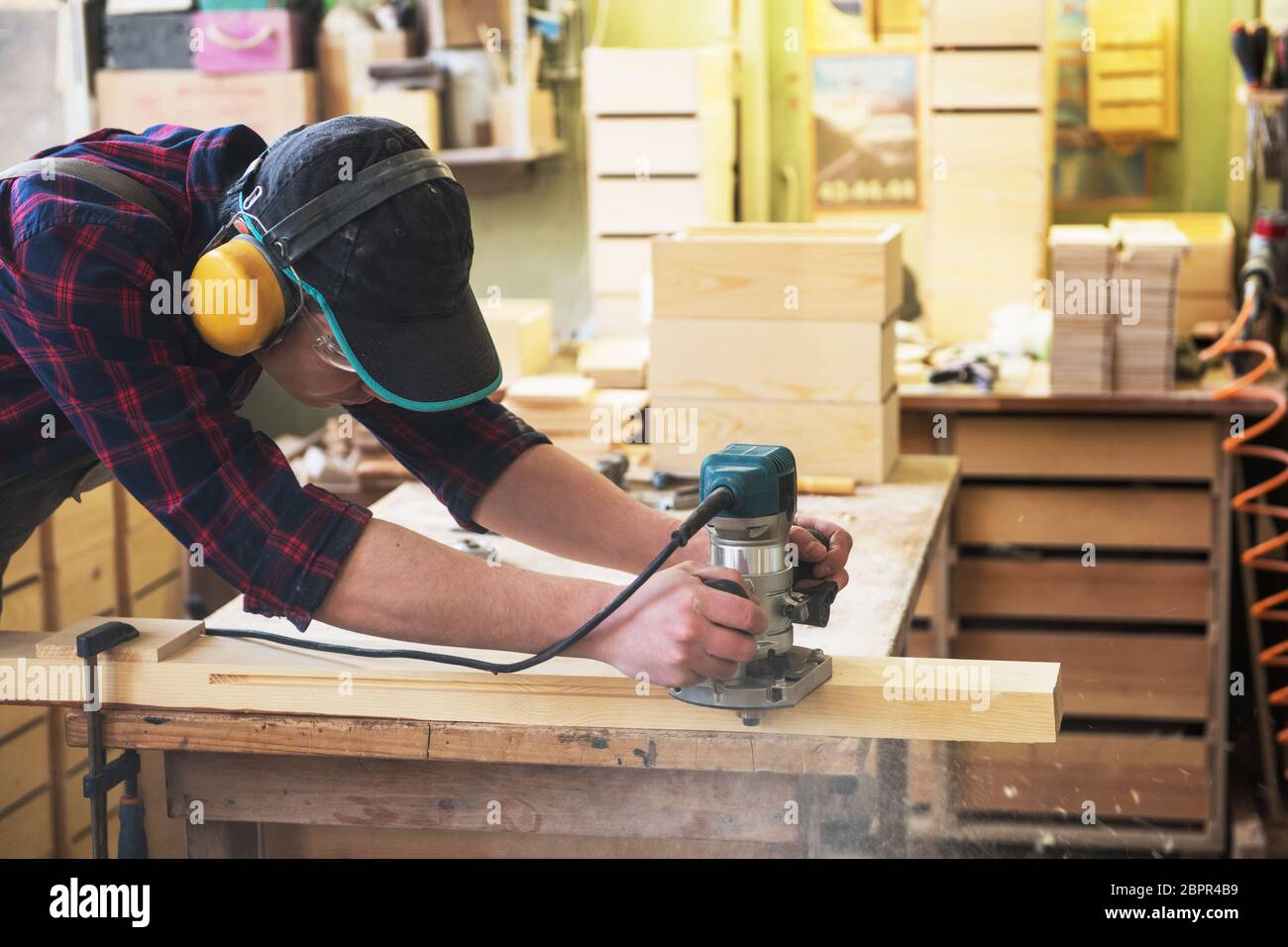 Worker grinds the wood box of angular grinding machine. Profession ...