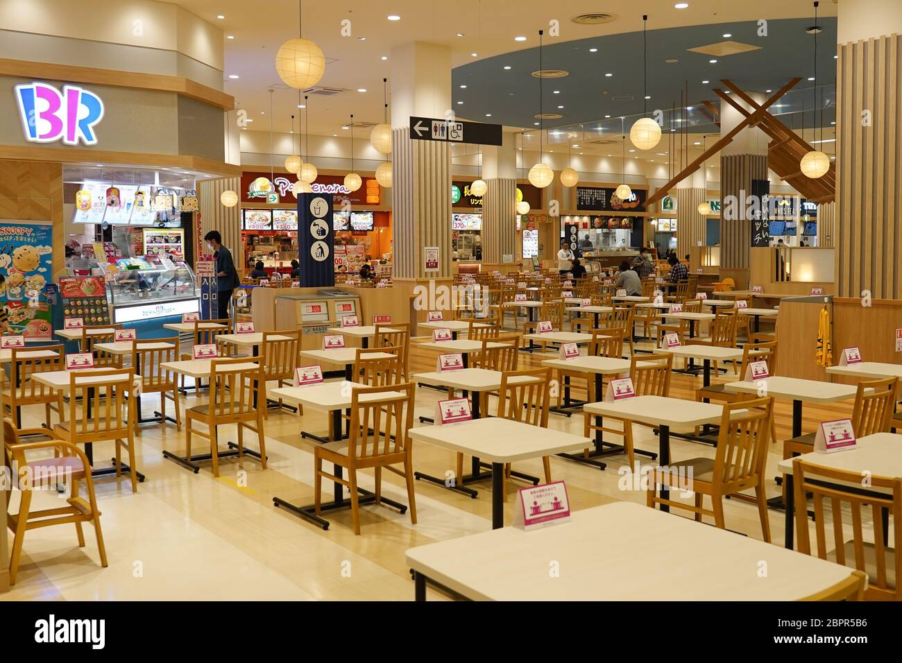 An overview of a food court set up shows chairs and tables set at a ...