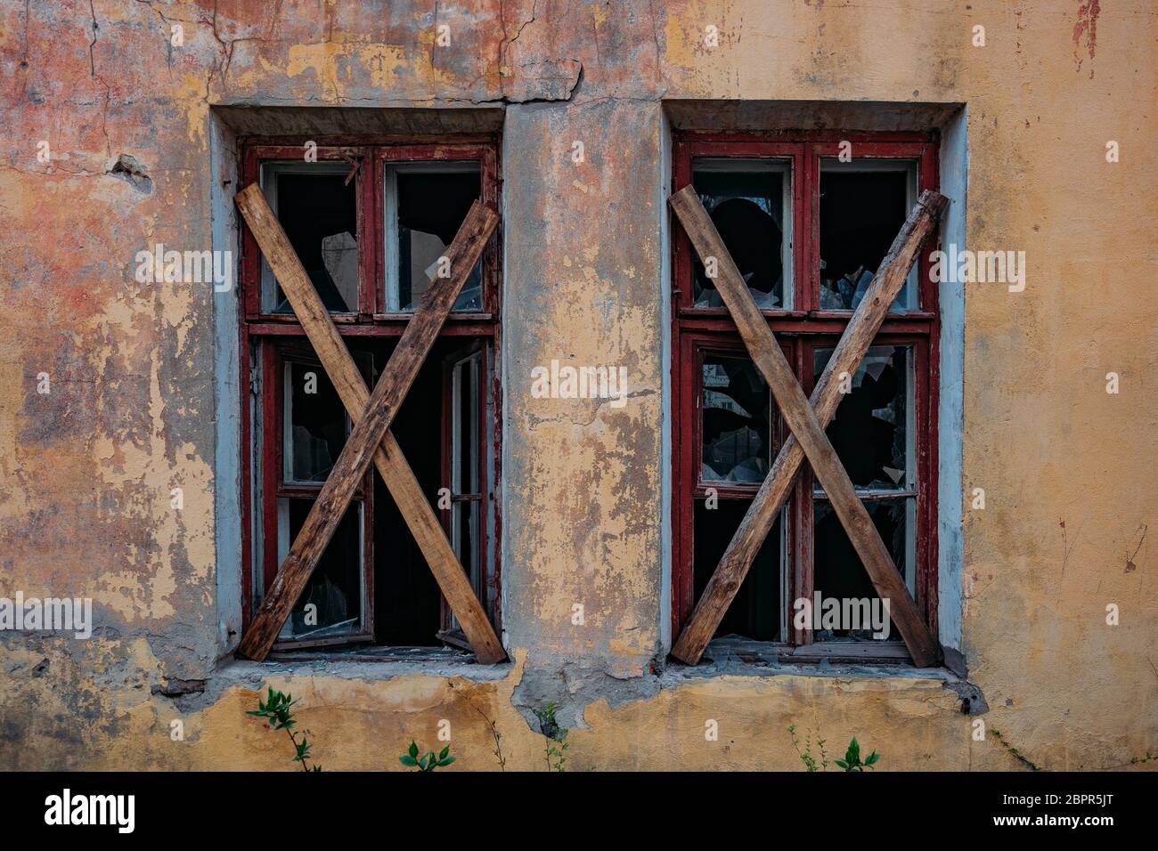 Wall of abandoned building with broken boarded up windows Stock Photo ...