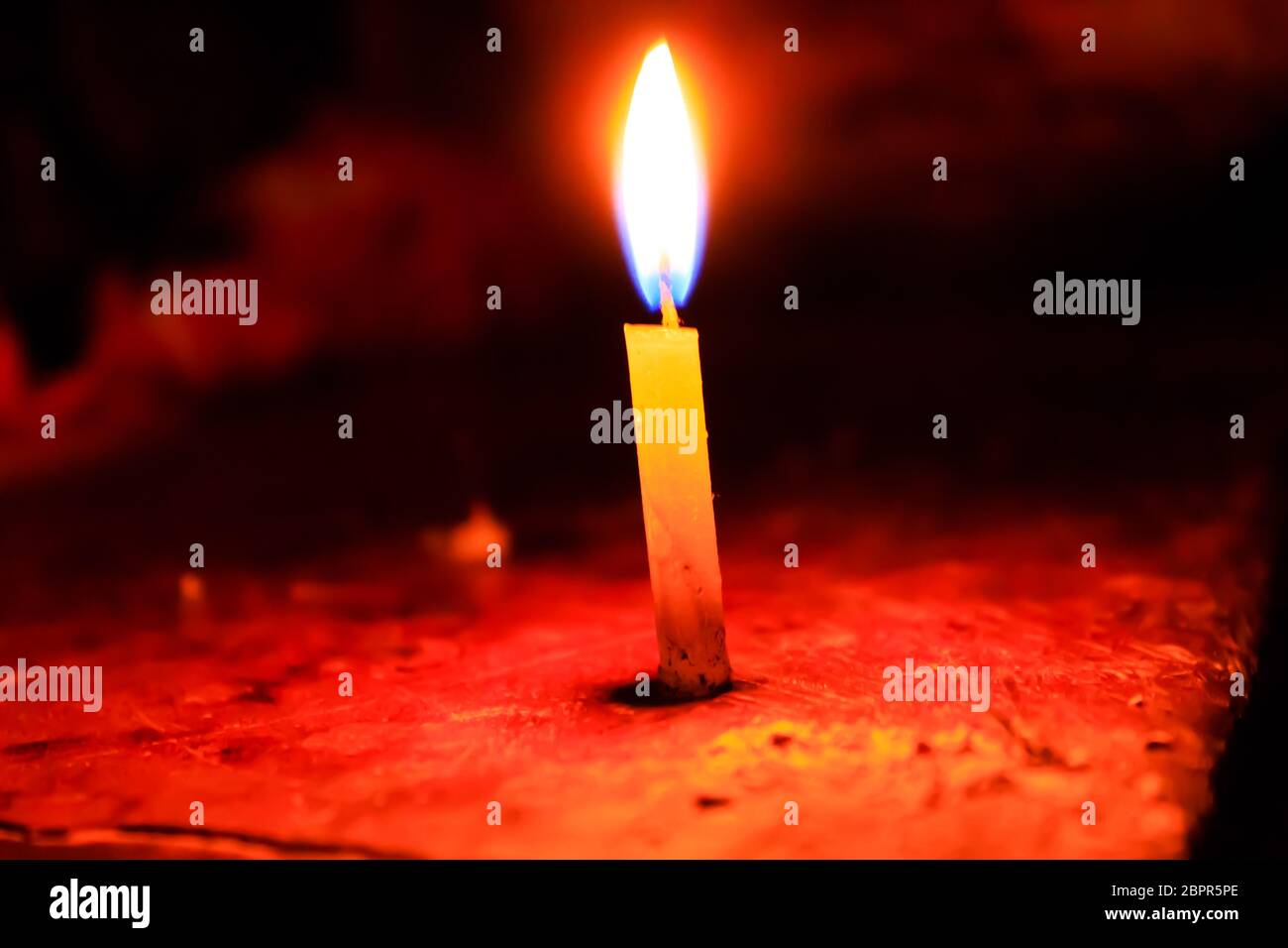 Candle spreading light isolated on blur background Stock Photo - Alamy