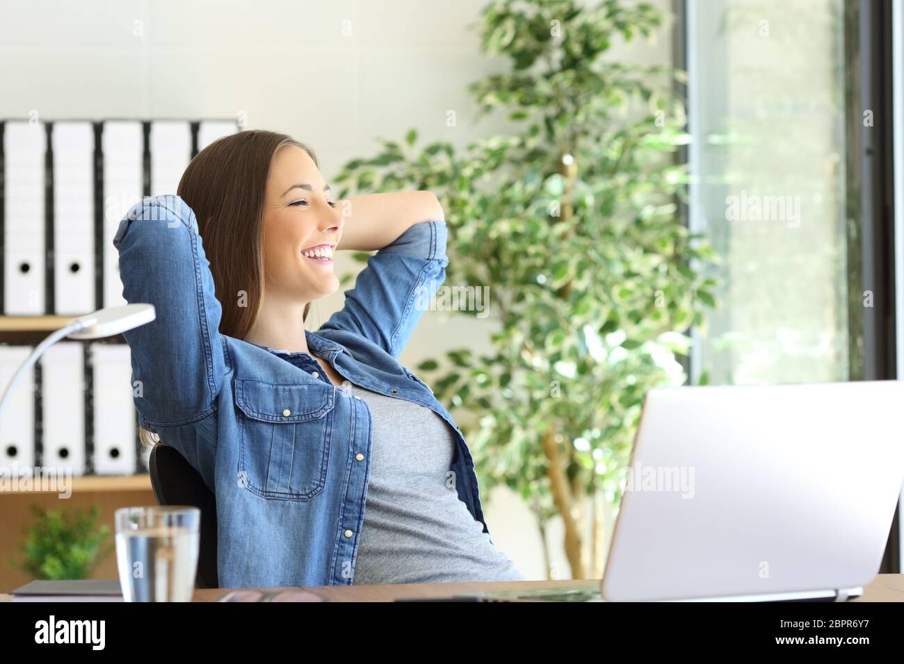 Side view of a satisfied entrepreneur with a new job looking through ...