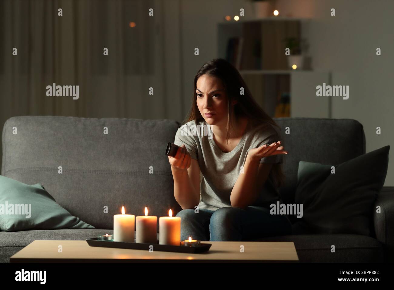Angry woman trying to watch tv during a blackout Stock Photo - Alamy