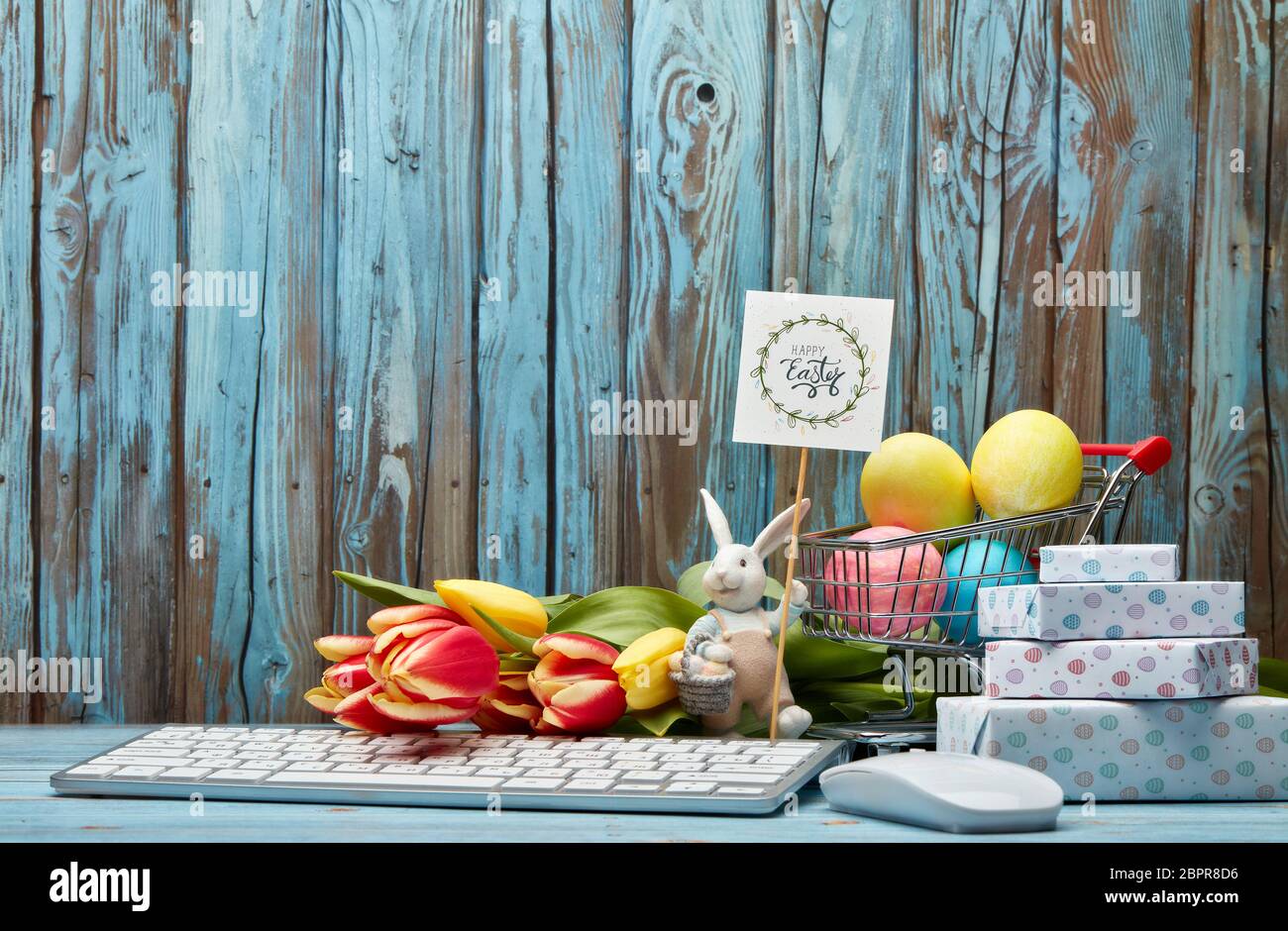 Colored easter eggs in shopping trolley, gift boxes, easter rabbit ...