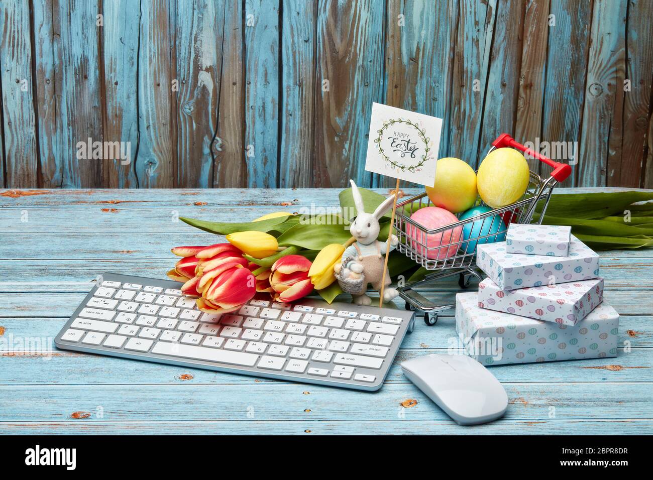 Colored easter eggs in shopping trolley, gift boxes, easter rabbit ...