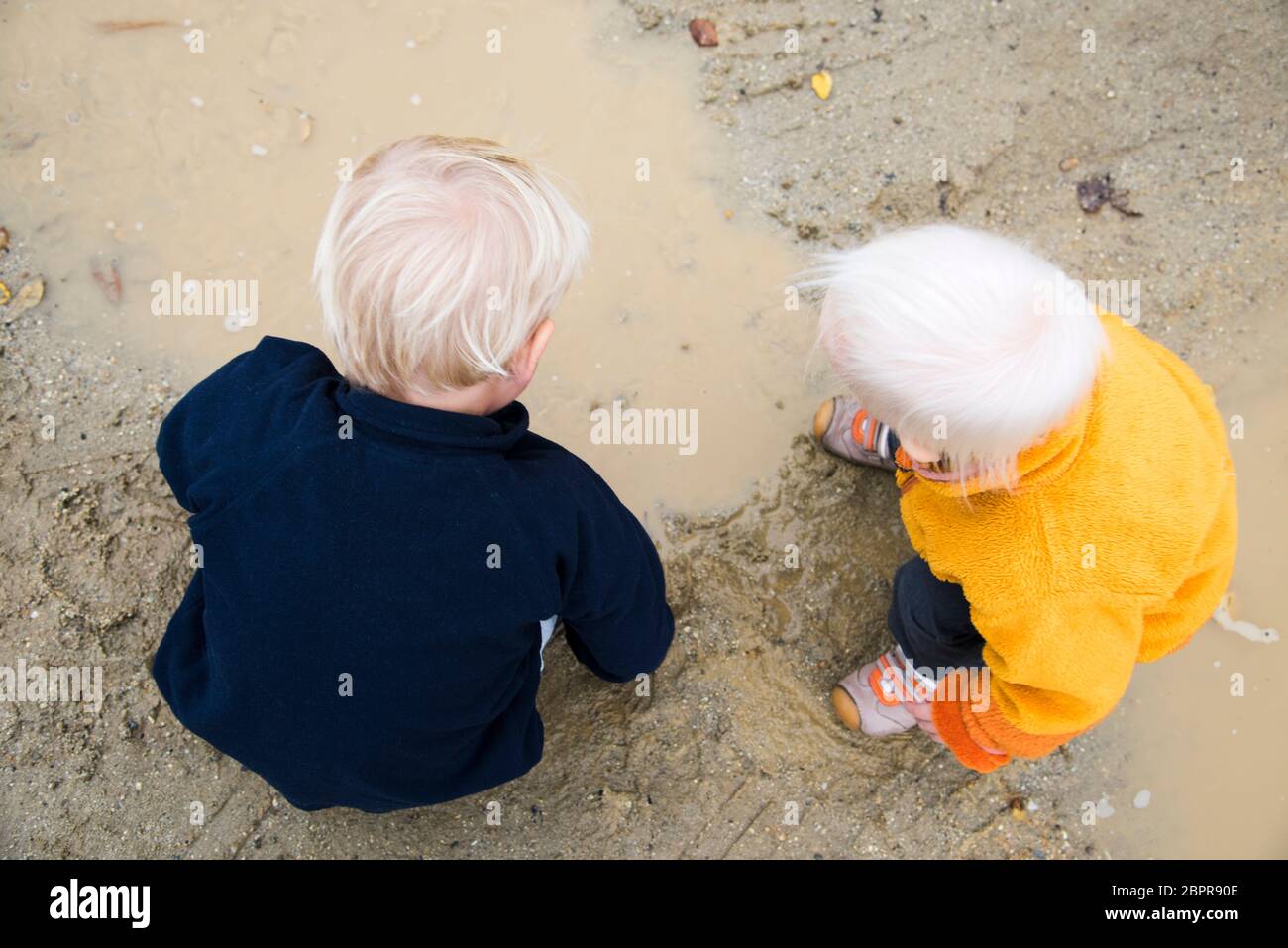 Two Blonde Brothers, Kids, Playing At A Puddle. Fun With Mud. Happy ...