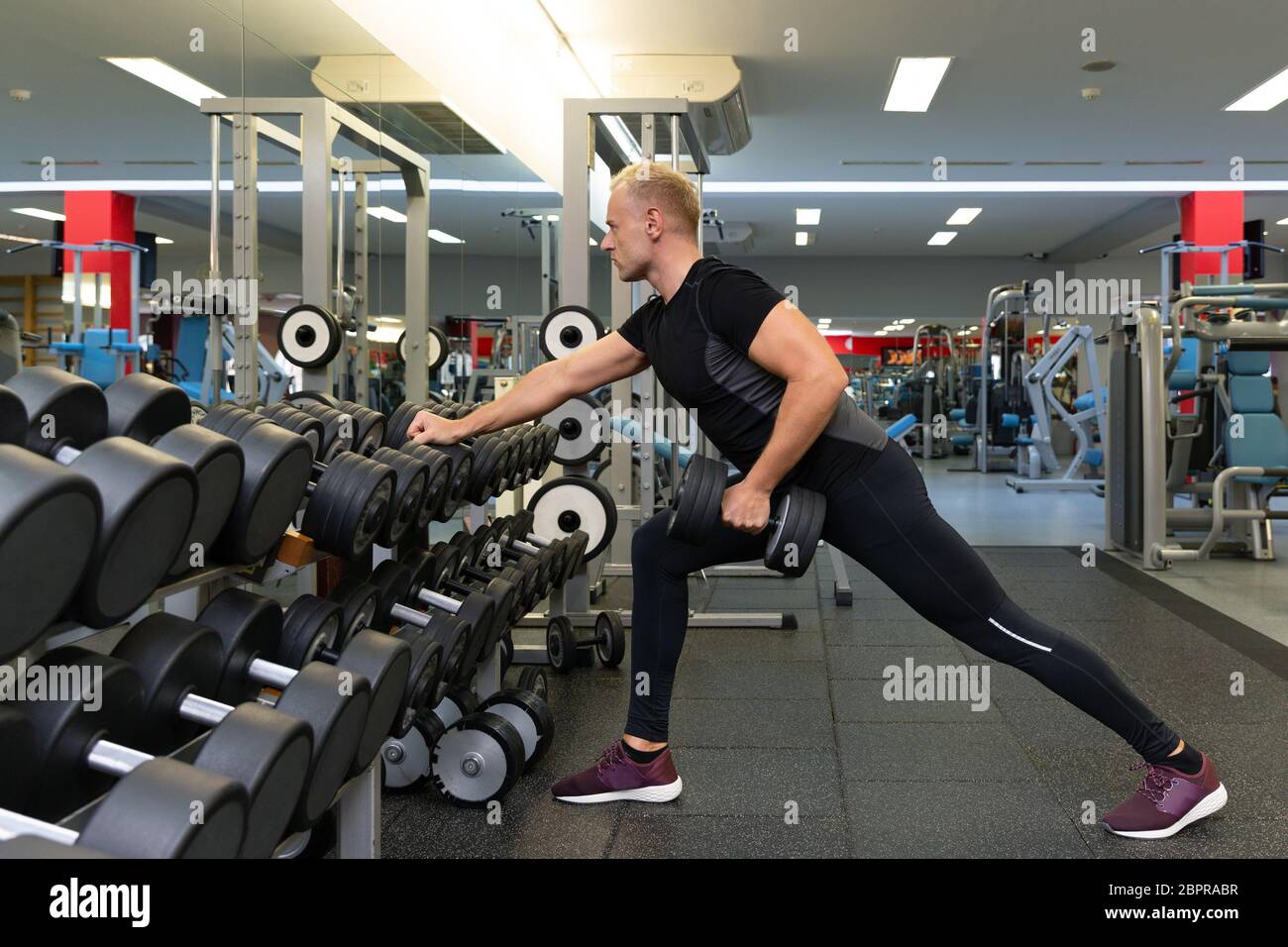 Young man doing the exercises with dumbbell at biceps for good body in ...