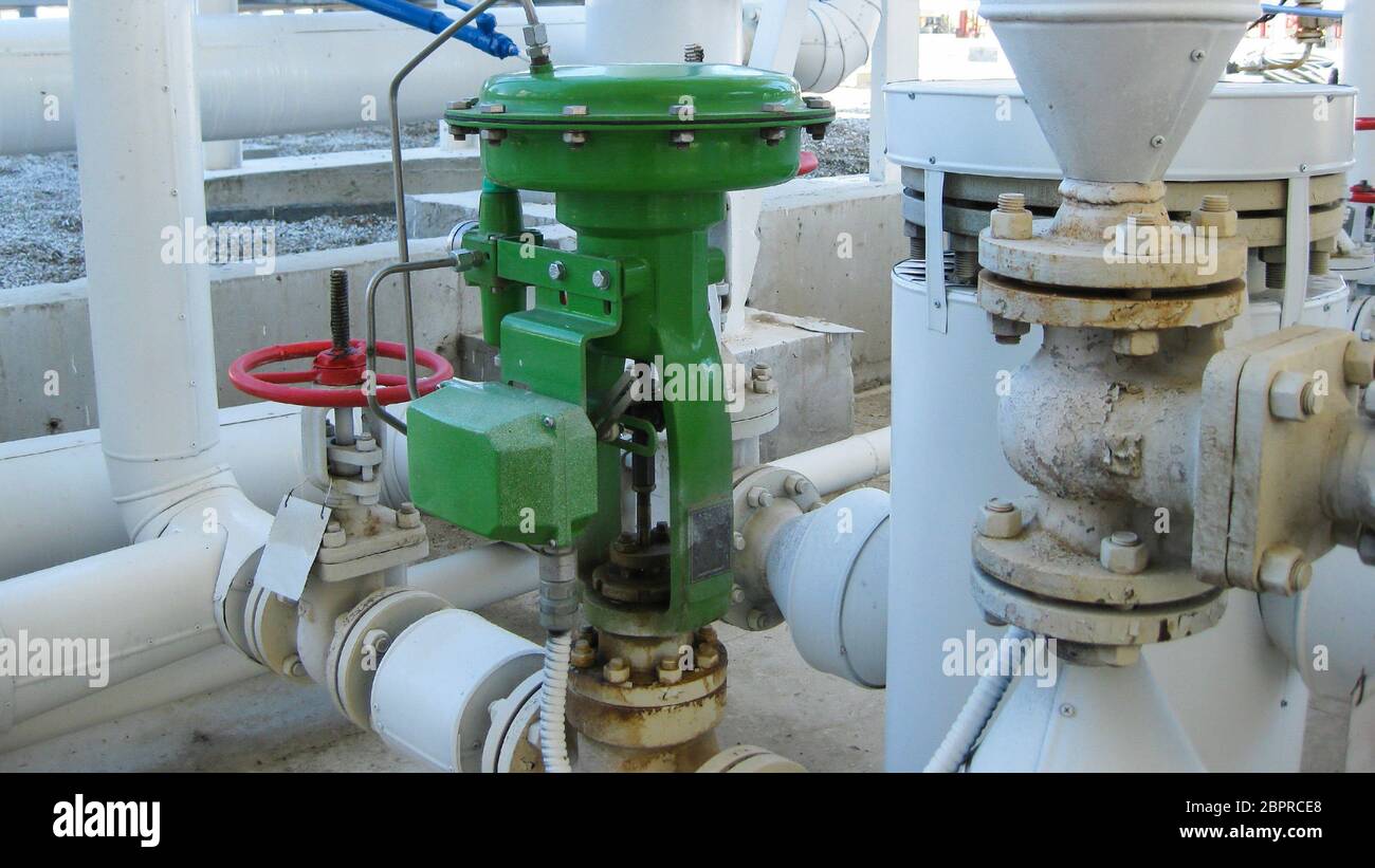 Green pneumatic valve on the pipeline. The equipment of the oil plant ...