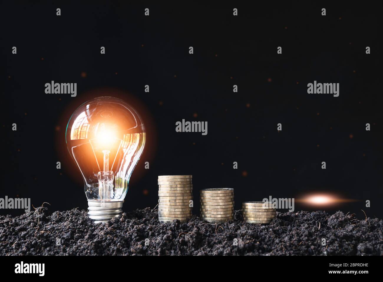A light bulb on stack of coins for business and accounting concept ...