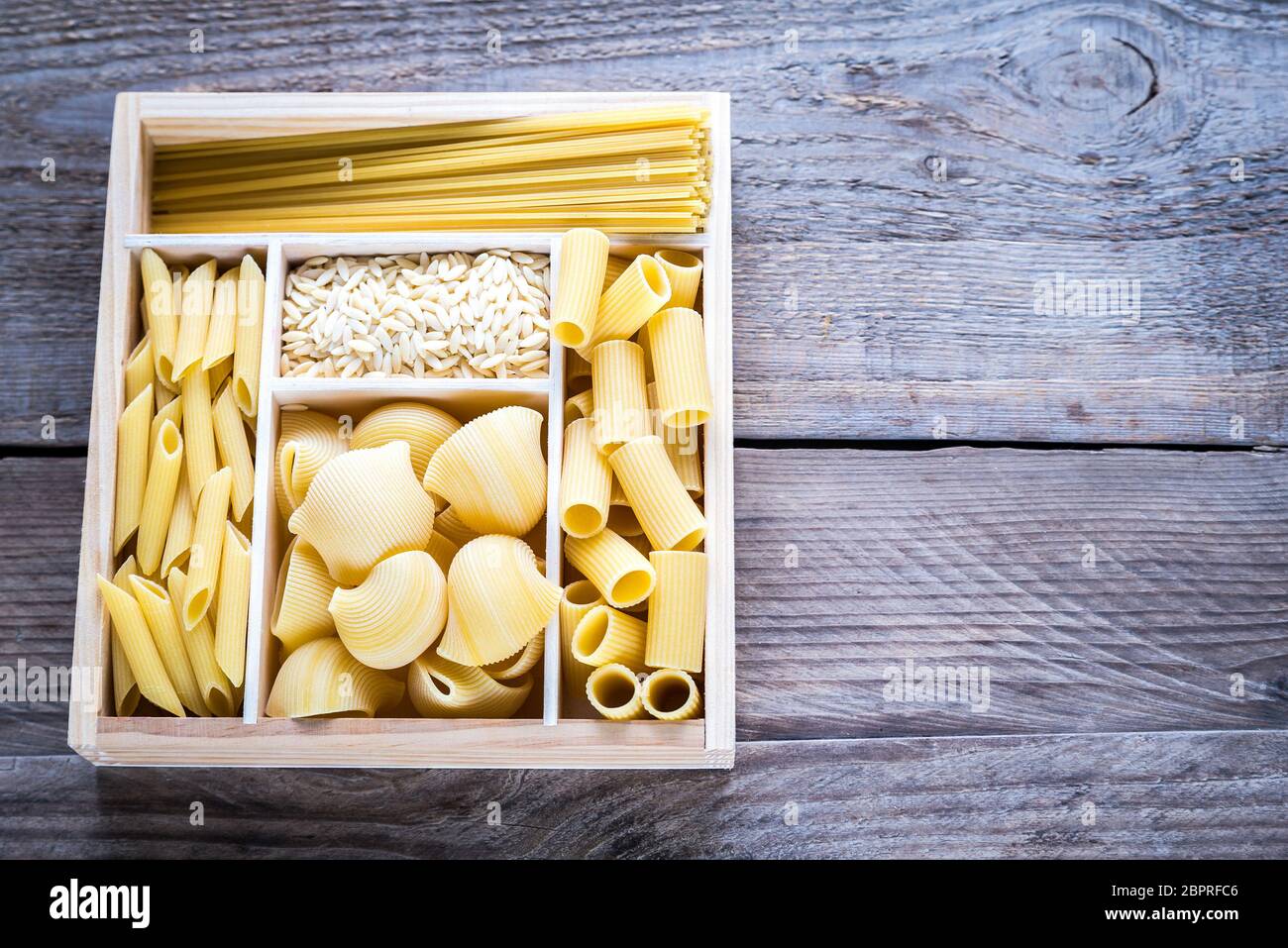 Various types of pasta in the wooden container Stock Photo - Alamy