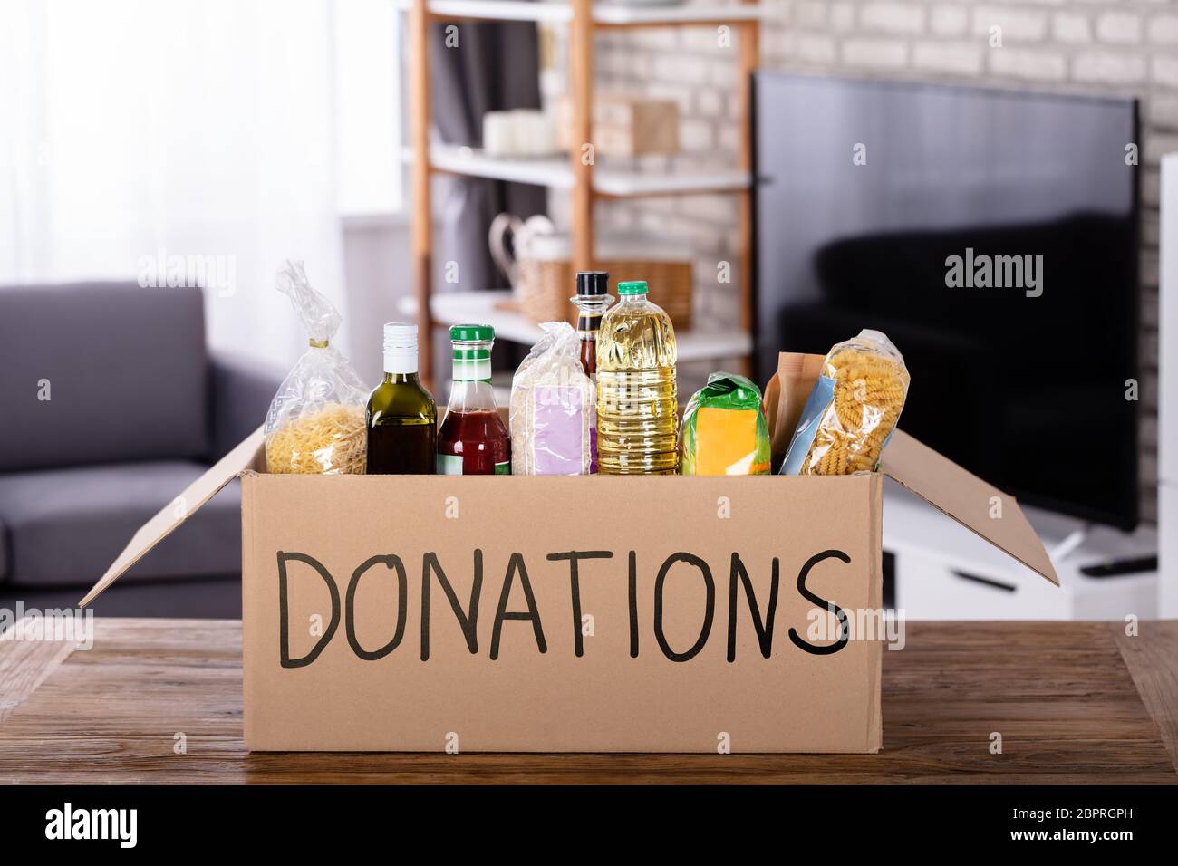 Various Food Items In Donation Box On Wooden Table Stock Photo - Alamy