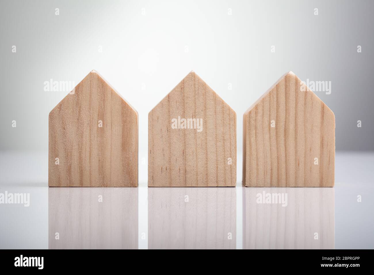 Close-up Of Wooden Houses Arranged In Row On White Desk Stock Photo - Alamy