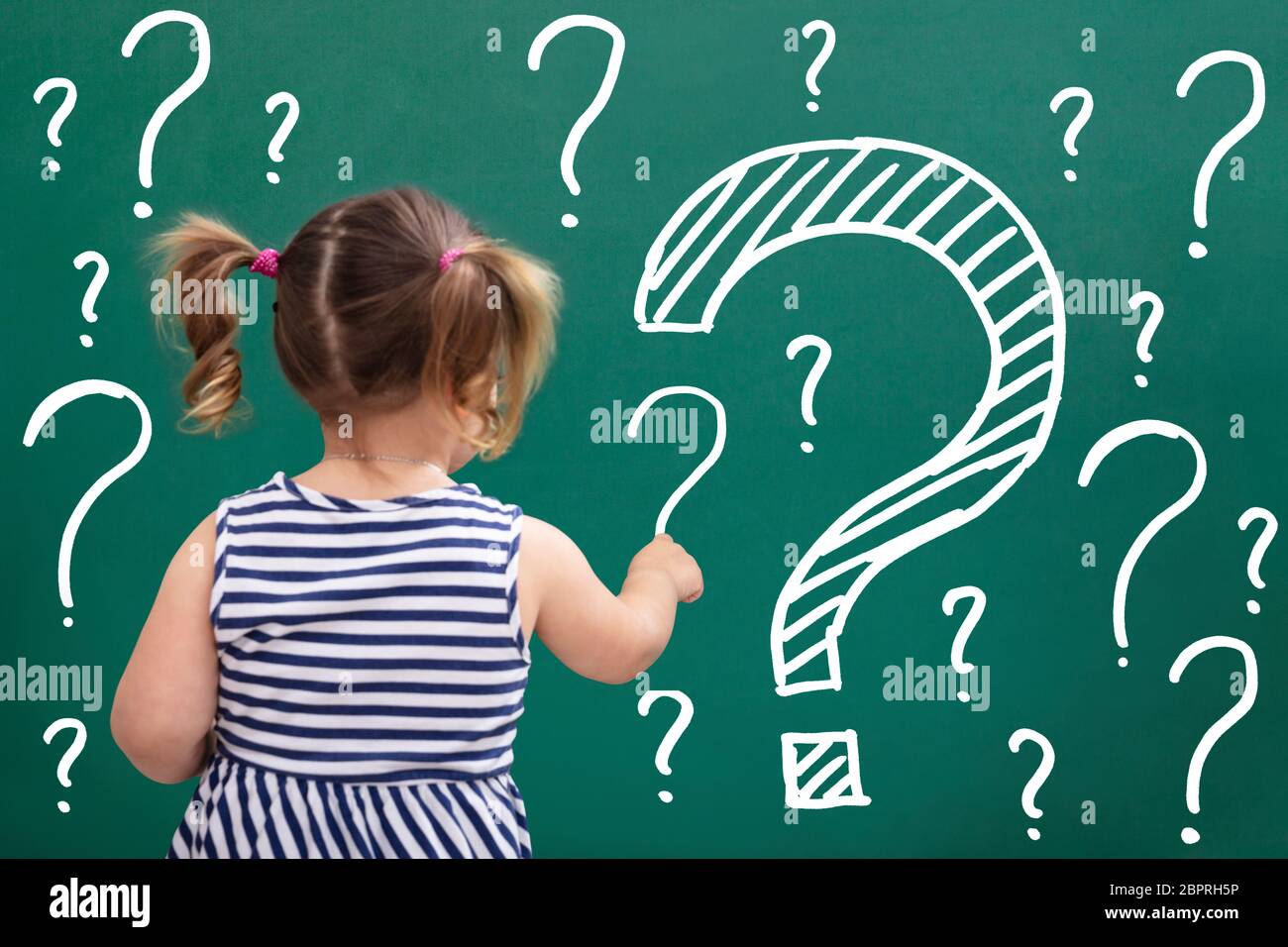 Rear View Of Little Girl Writing Question Marks On Chalkboard Stock ...