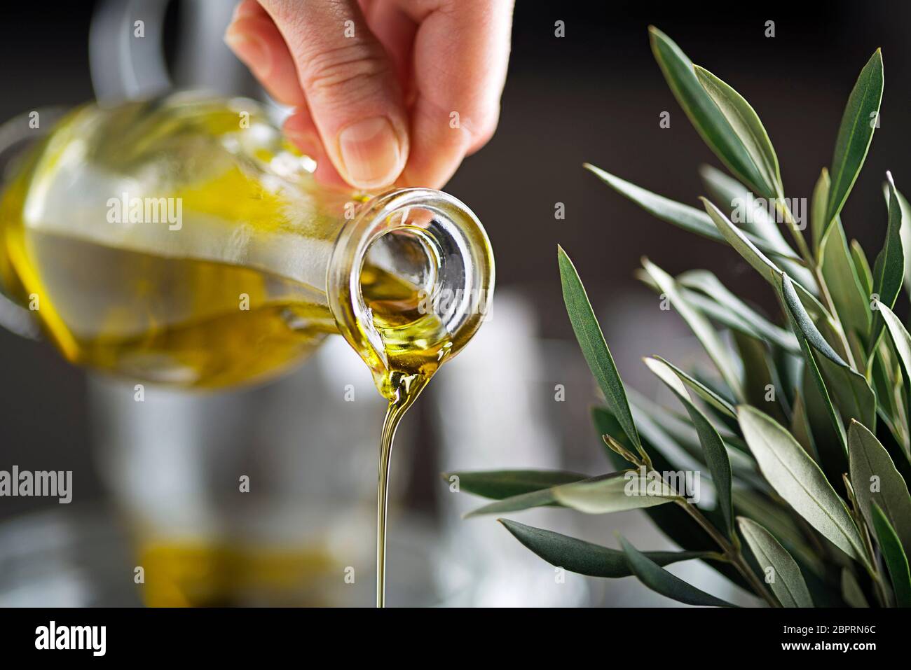 Bottle of virgin olive oil pouring close up Stock Photo - Alamy