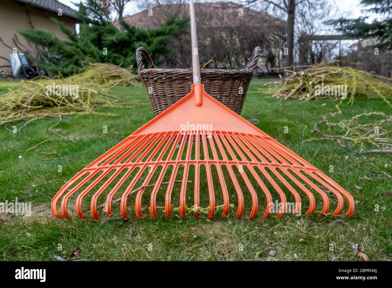 Orange rake next to a basket Stock Photo - Alamy