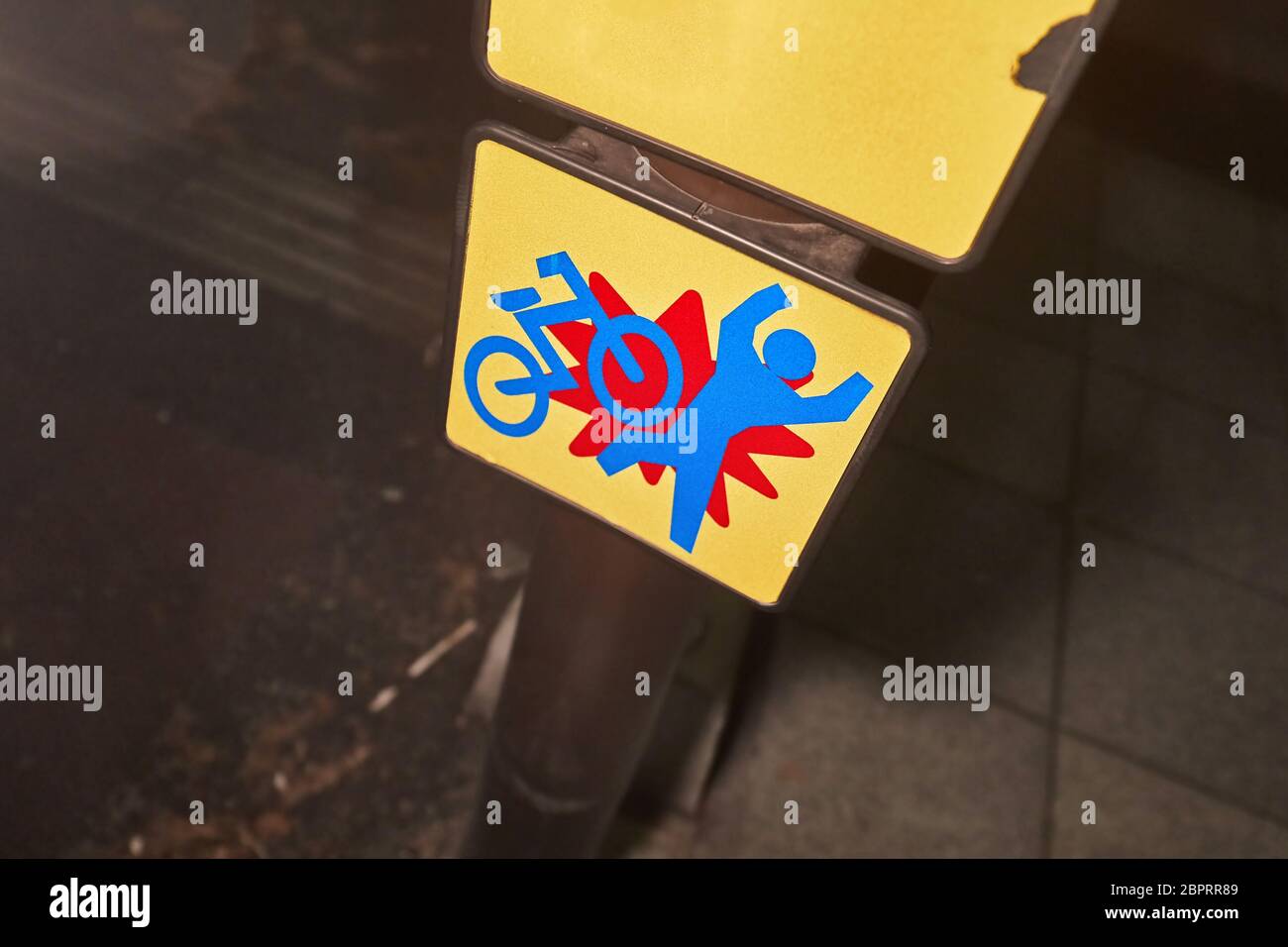Bicycle traffic warning sign on a sidewalk Stock Photo - Alamy