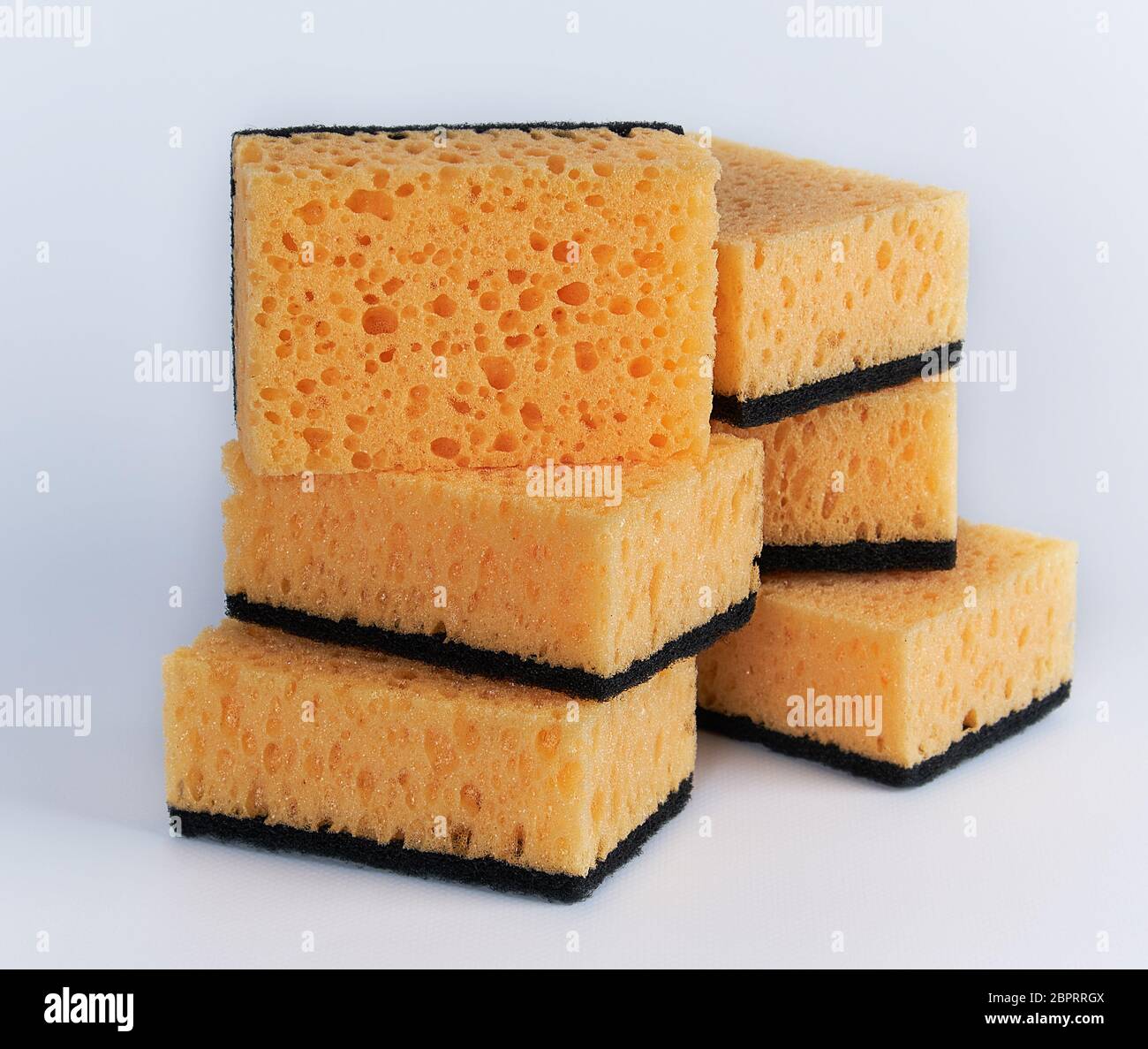 stack of yellow kitchen sponges for washing dishes on a white ...