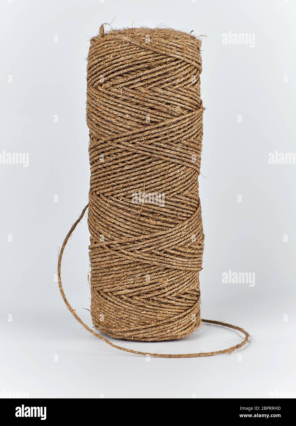 spool-wrapped brown rope of jute, white background Stock Photo - Alamy
