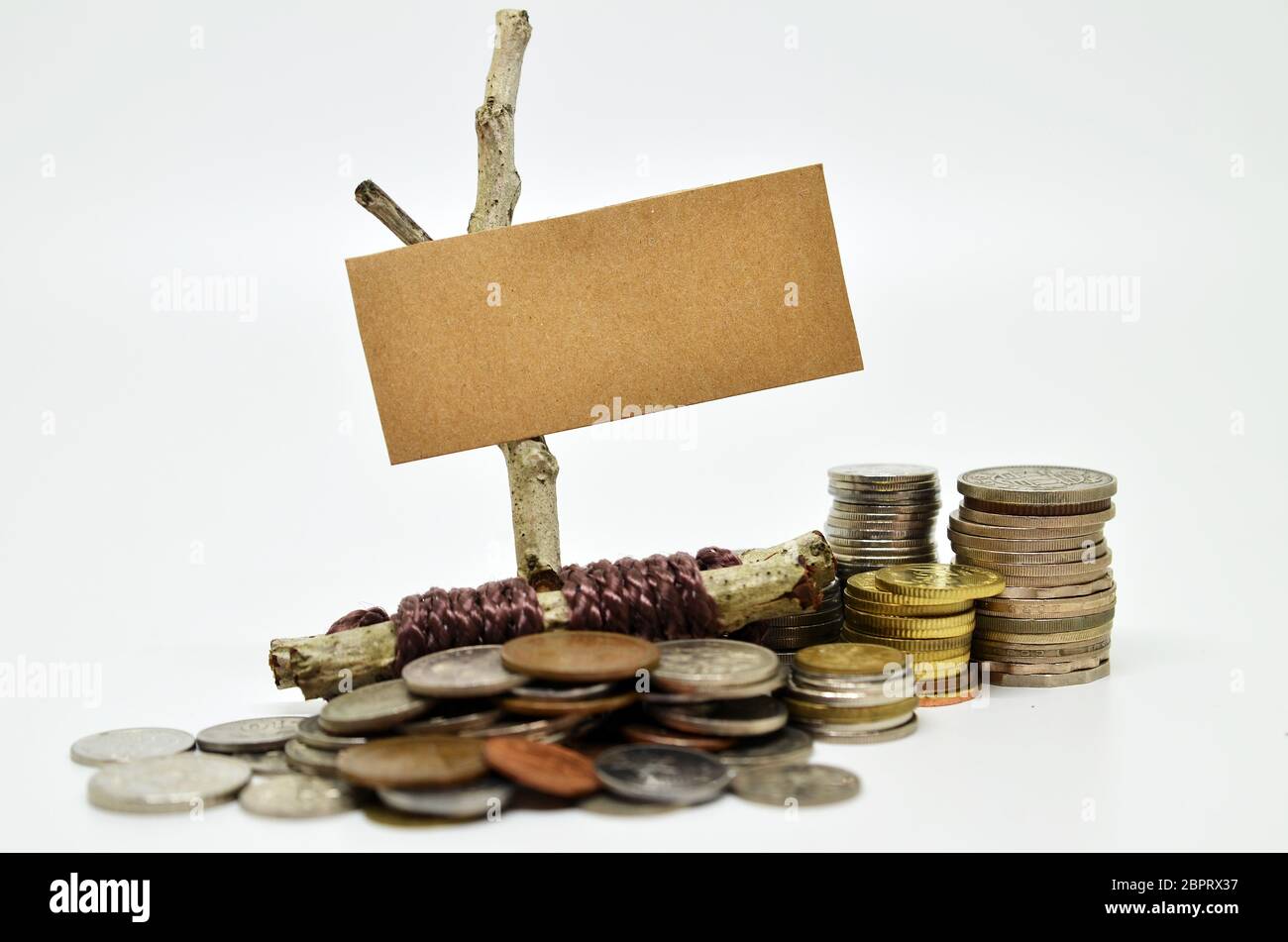 Paper sign board with stack of coins on white background Stock Photo ...