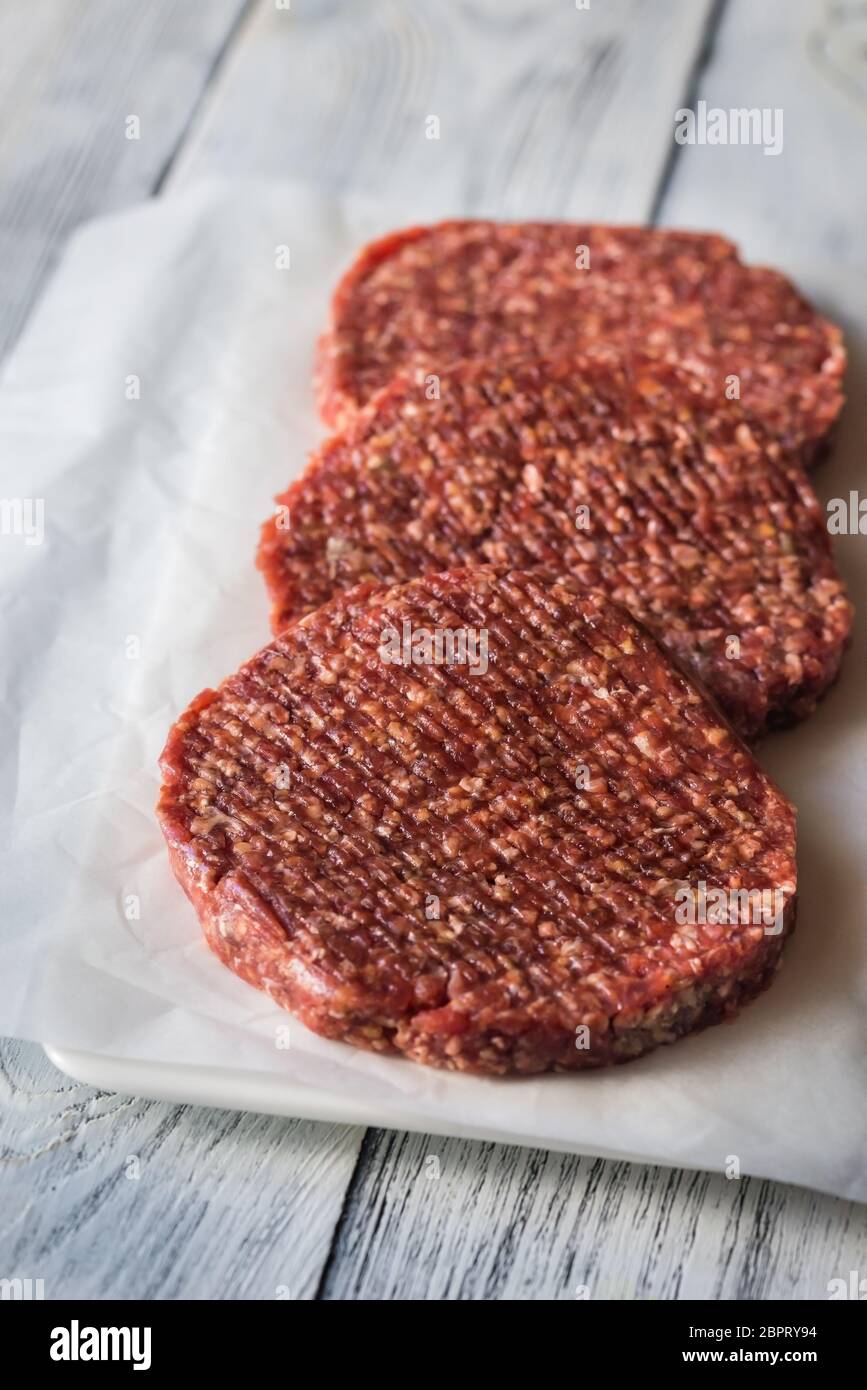 Raw beef patties on the white parchment Stock Photo - Alamy