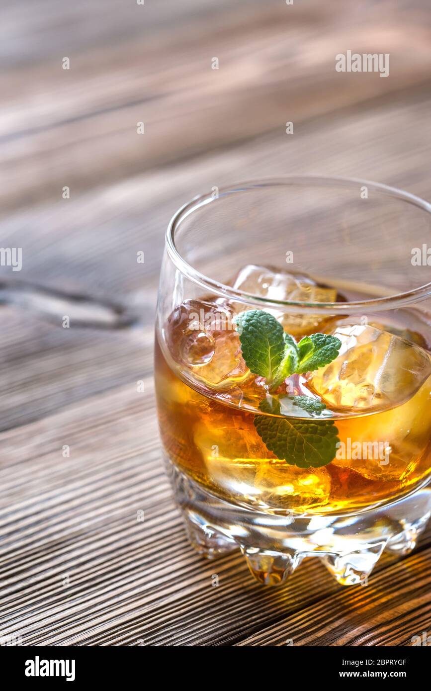 Glass of rum on the wooden background Stock Photo - Alamy