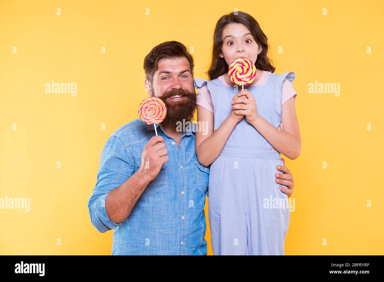Sweet food. Girl child and dad hold lollipops. Sweet dessert. Loving ...