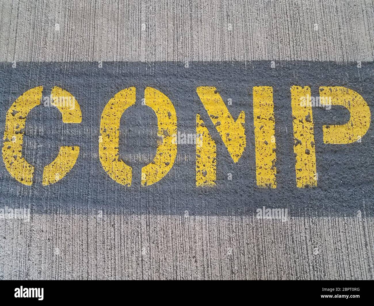 yellow letter spelling comp on grey cement or pavement Stock Photo - Alamy