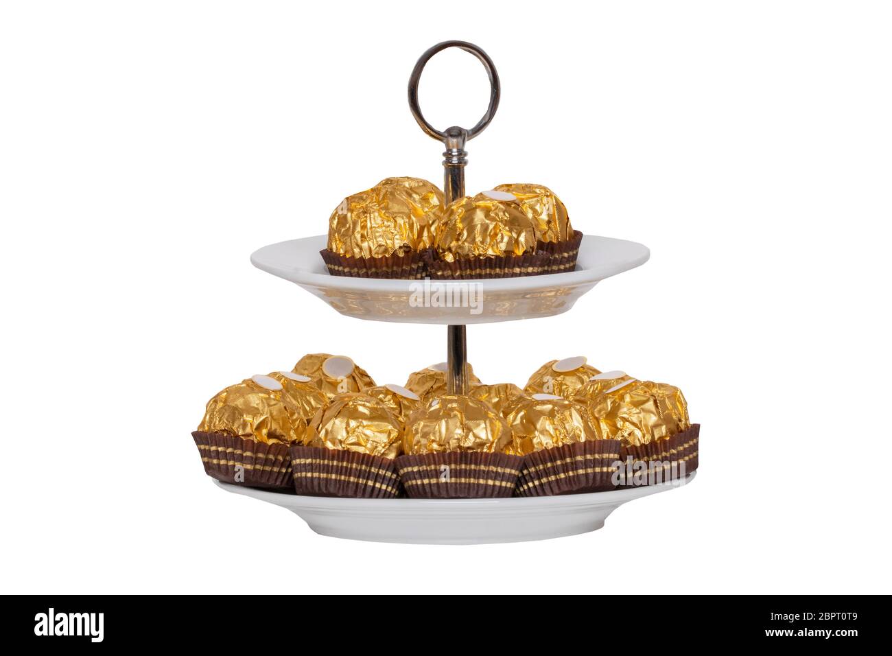 Sweets isolated. Closeup of sweets wrapped in gold paper on an etagerie ...