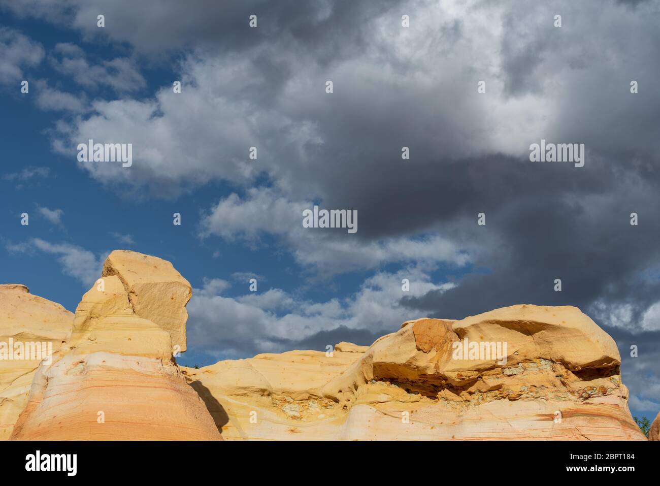 Landscape of yellow rock formations and dramatic clouds Stock Photo - Alamy