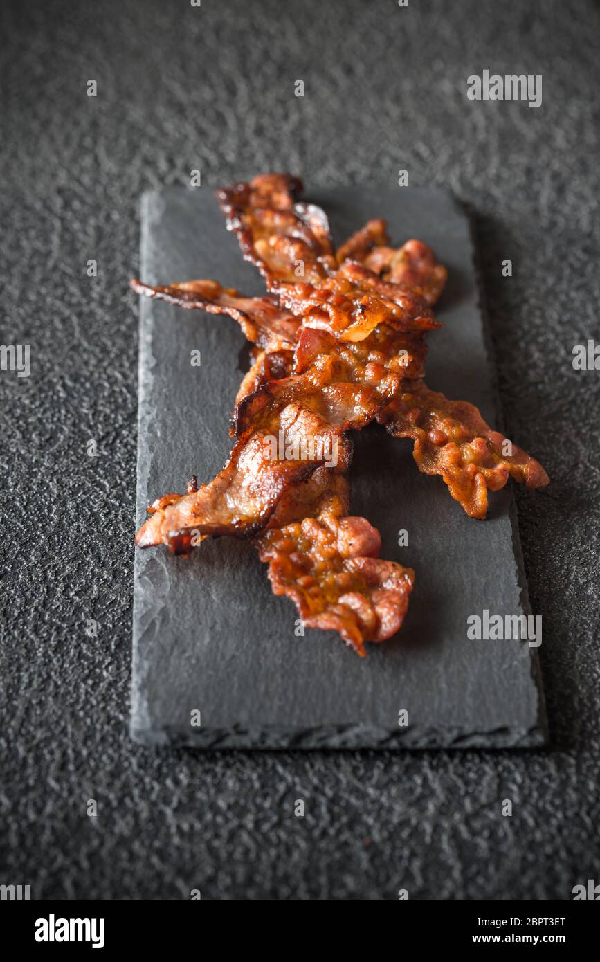 Fried bacon strips on the stone dark board Stock Photo - Alamy