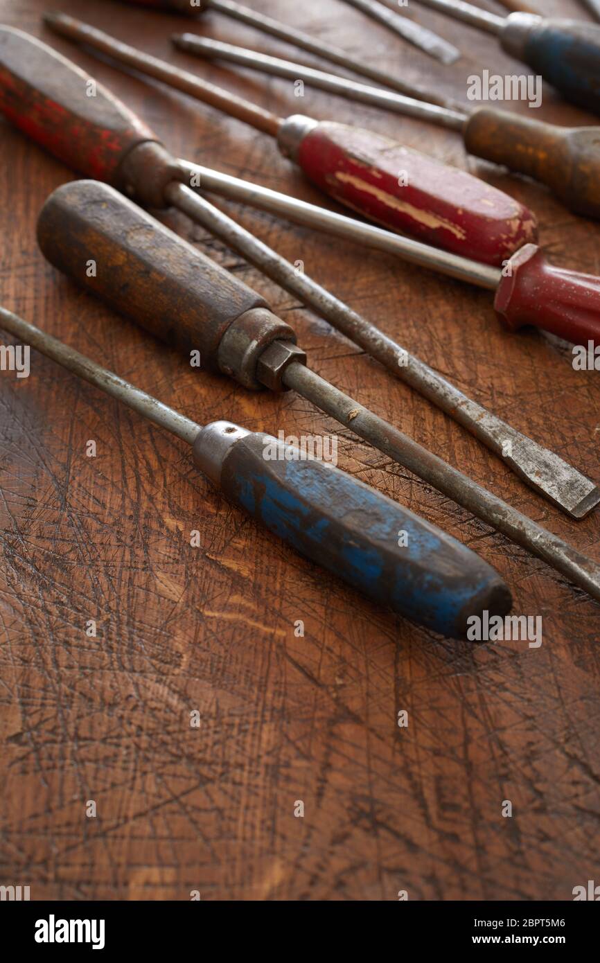 Old dirty worn vintage wooden handled screwdrivers high angle on a ...