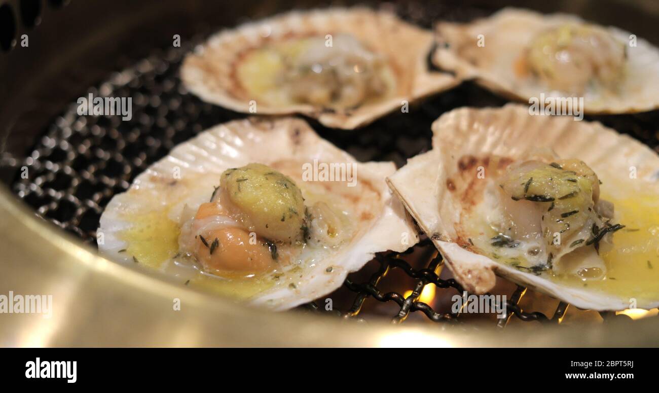Scallop on metal net barbecue in restaurant Stock Photo - Alamy