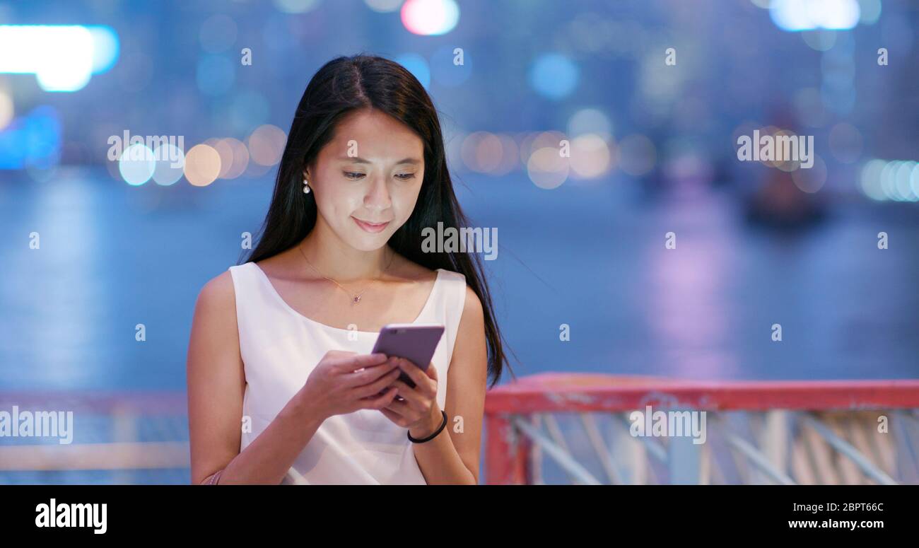 Woman use of mobile phone online at night Stock Photo - Alamy