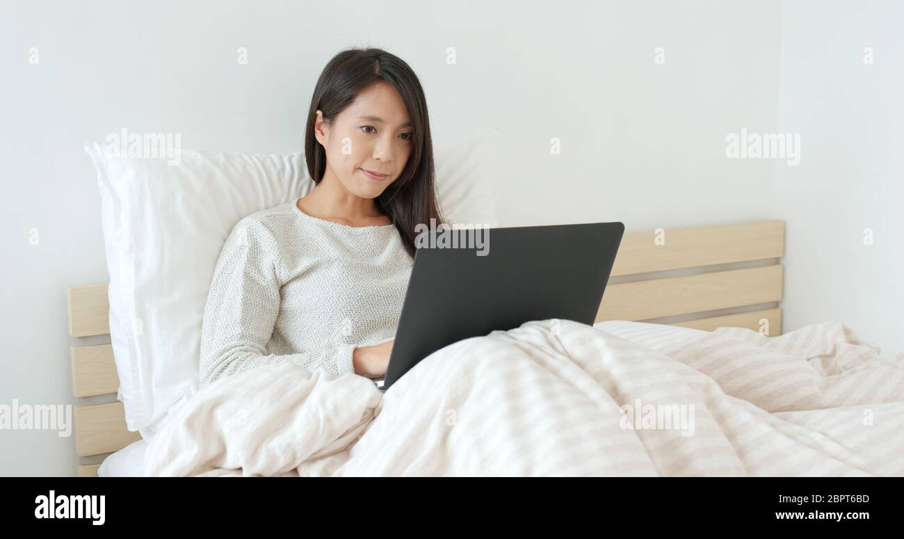 Woman working laptop computer on bed Stock Photo - Alamy