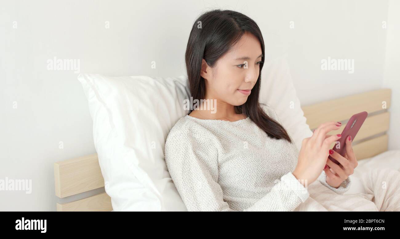 Woman use of mobile phone on bed Stock Photo - Alamy