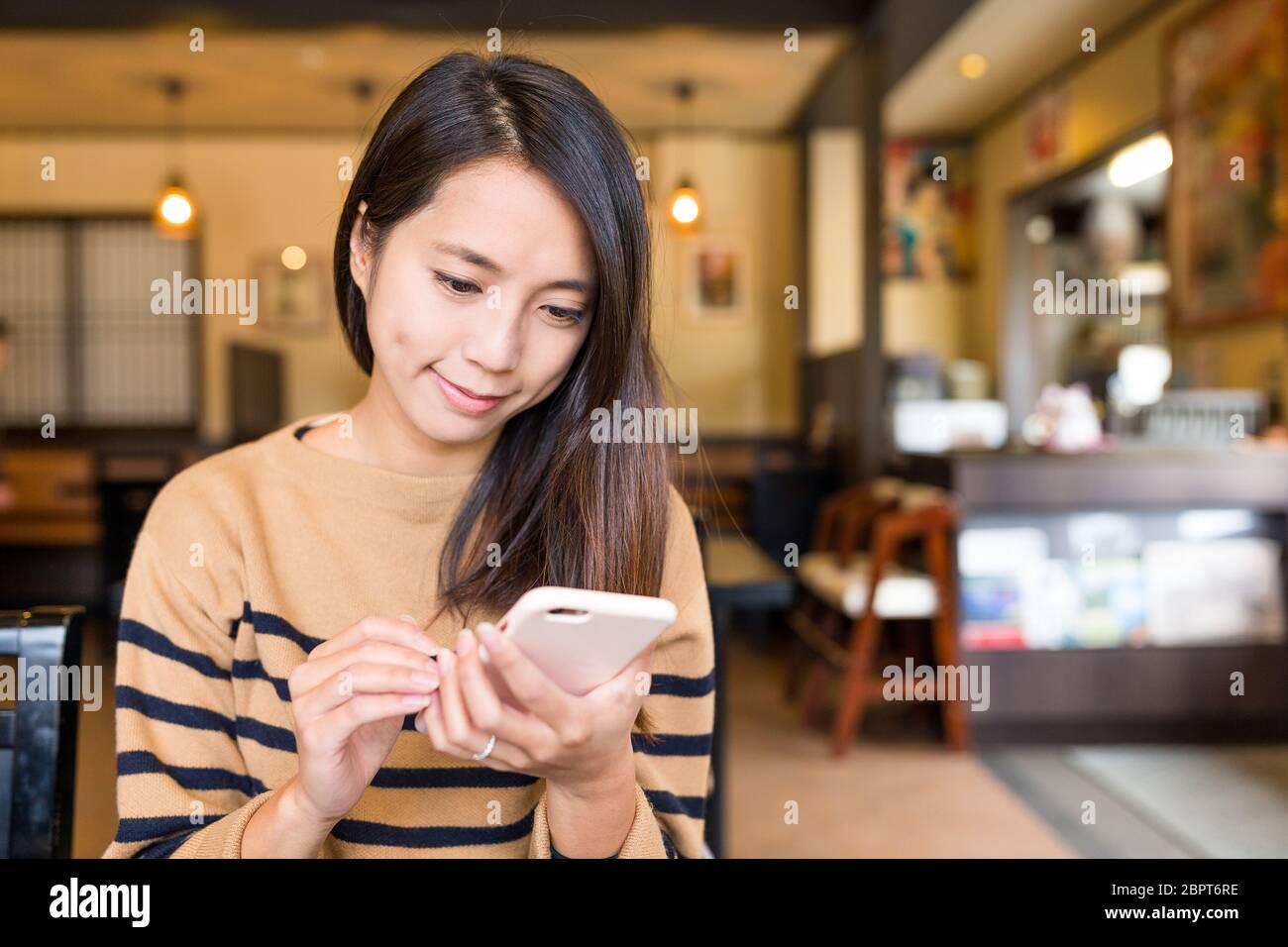 Woman use of mobile phone in restaurant Stock Photo - Alamy