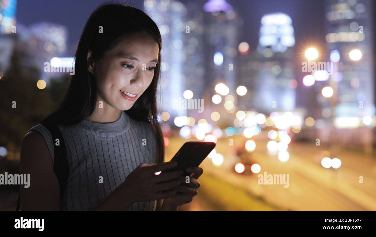 Woman using of mobile phone city at night Stock Photo - Alamy