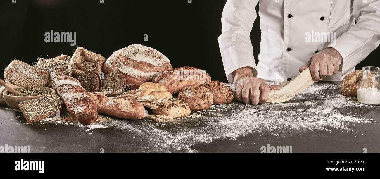 Baker kneading raw dough while making assorted speciality bread ...